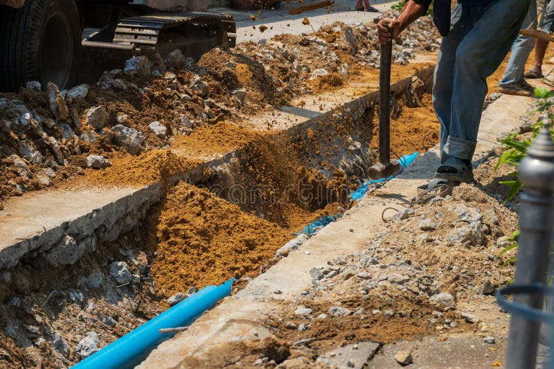 Construction Worker Digging Trench for Pipeline Installation in Urban ...