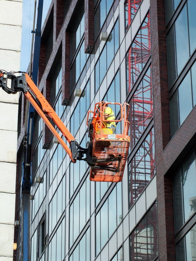A Worker on a Hydraulic Construction Platform on a Large Building Site ...