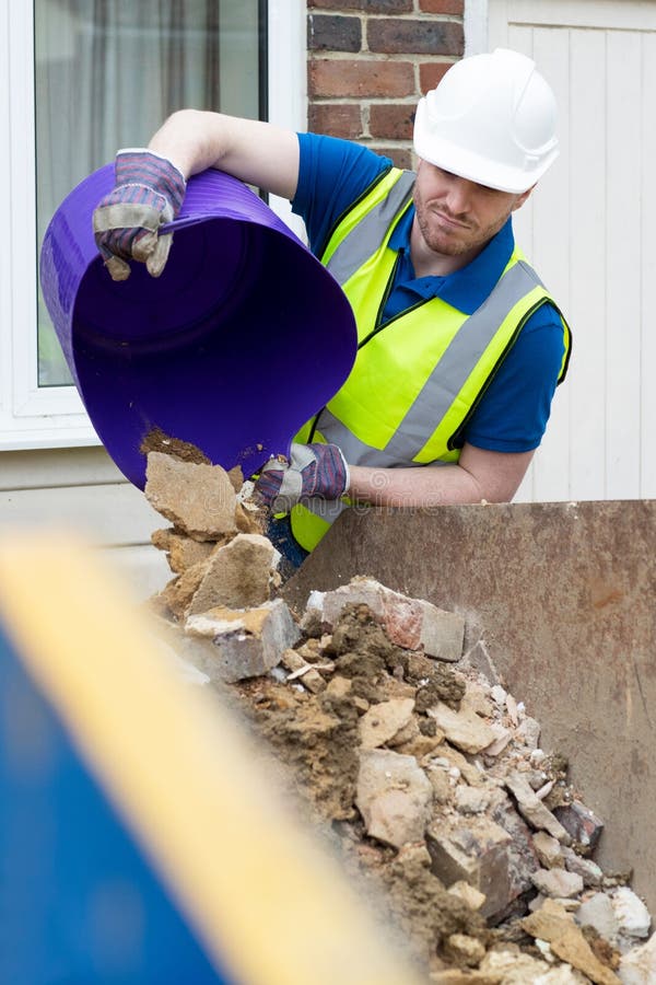 Construction Worker Emptying Building Waste into Skip Outside Renovated ...