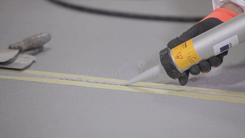Construction Worker Grouting Seams in Concrete Floor. the Builder ...