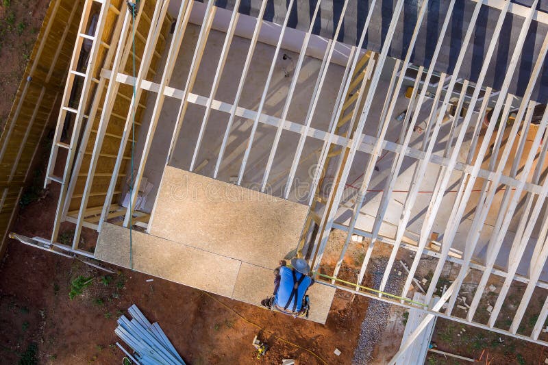 Construction Worker Hammering Nails into OSB Plywood Panel on a Roof ...