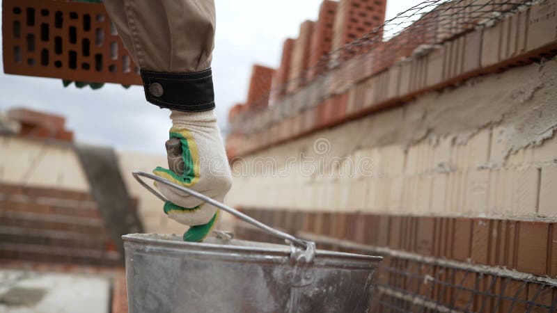 Construction Worker Picking Up Trowel from Bucket while Building Brick ...