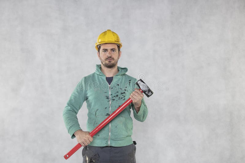 The Construction Worker is Holding a Hammer, Ready for Demolition Tasks ...