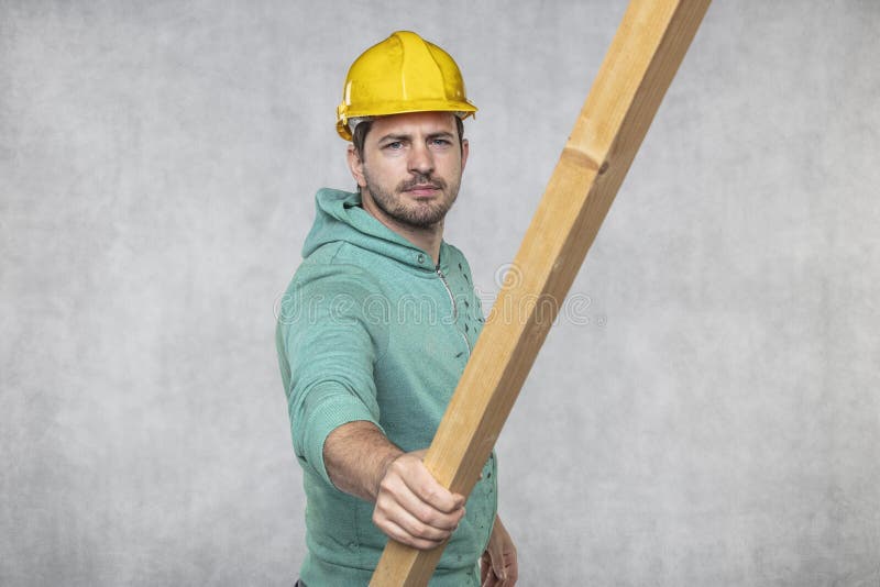 The Construction Worker Holds a Piece of Board in His Hands, the ...