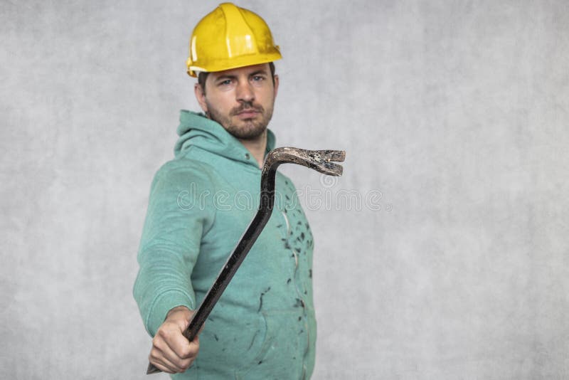 The Construction Worker Holds a Work Tool in His Hands, a Crowbar Stock ...