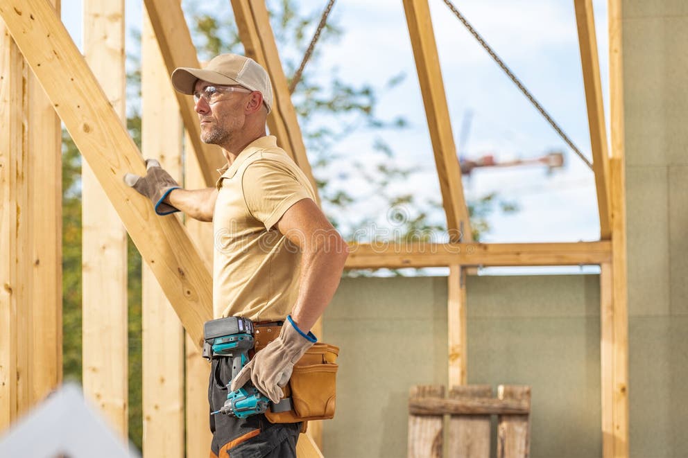 Construction Worker Inspecting Wooden Frame Structure in Bright Daylight at a Building Site ...