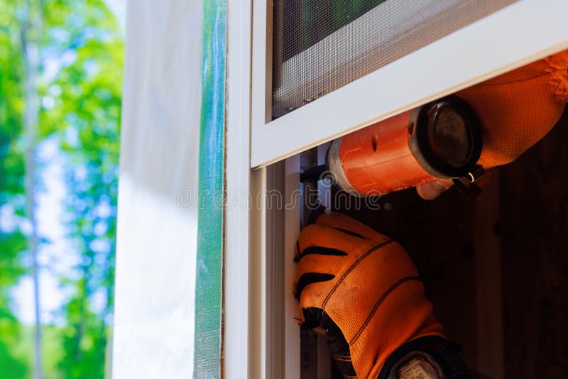 Construction Worker Installation of Plastic Windows with Screwdriver in ...