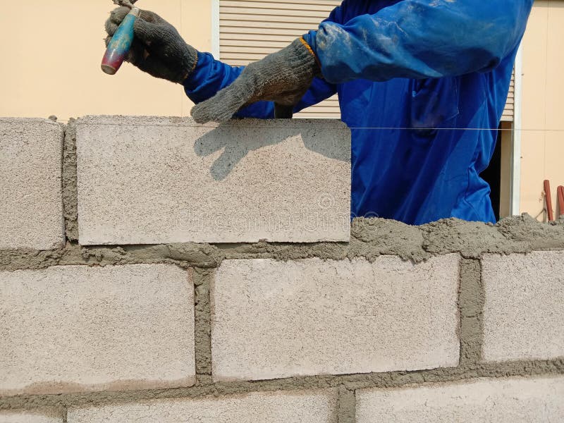 Construction Worker Installing Cement Blocks, Using a Trowel for Making ...