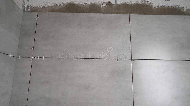 Construction Worker Installing Large Gray Tiles on Wall. Stock Image ...