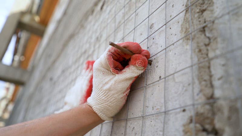 Construction Worker Installing Metal Mesh on Building Wall Using Nails ...