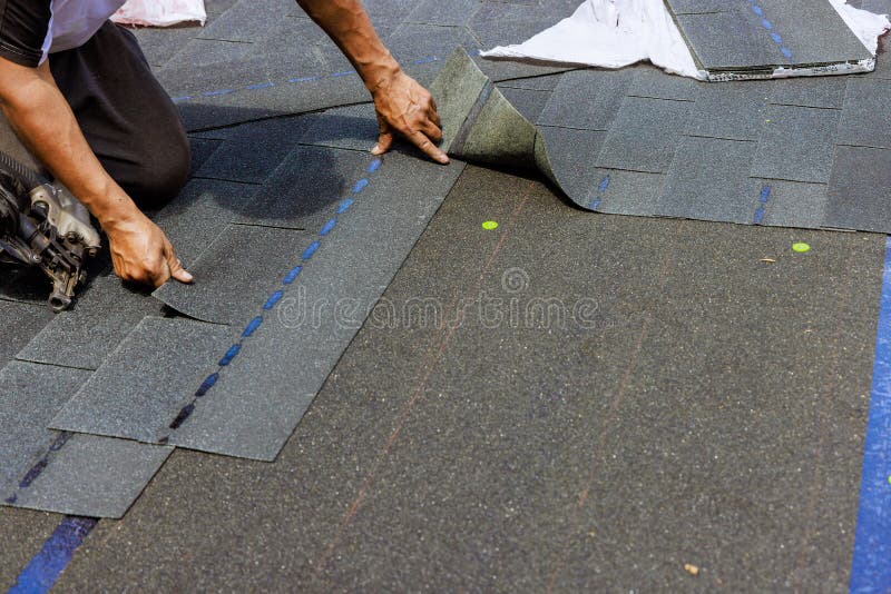 Construction Worker Installing New Bitumen Shingles on Roof House Stock ...