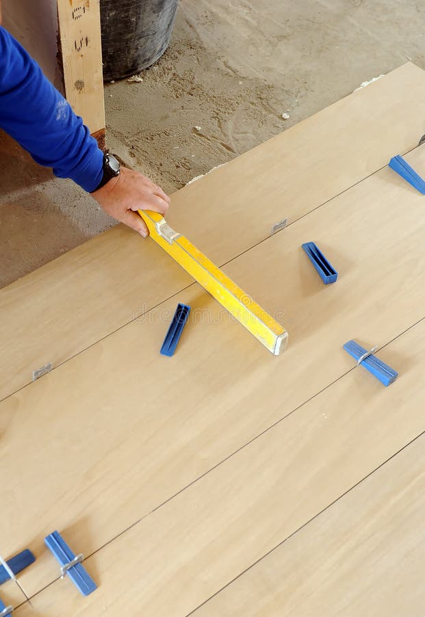 Bricklayer Checking the Leveling of a Porcelain Stoneware Floor with ...