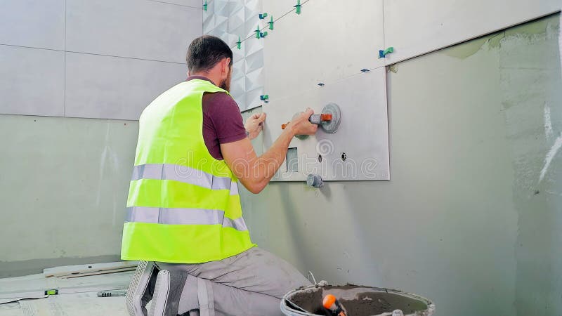 Construction Worker Installing Wall Tiles with Suction Tool. Back View ...