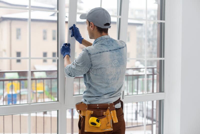 Construction Worker Installing Window in House. Handyman Fixing the ...