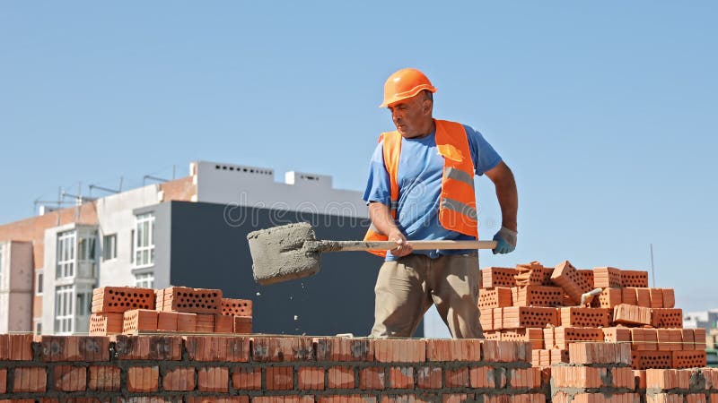 Construction Worker Laying Bricks on Wall, Spreading Cement Mortar with ...