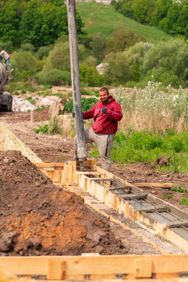 Construction Worker Laying Cement or Concrete into the Foundation ...