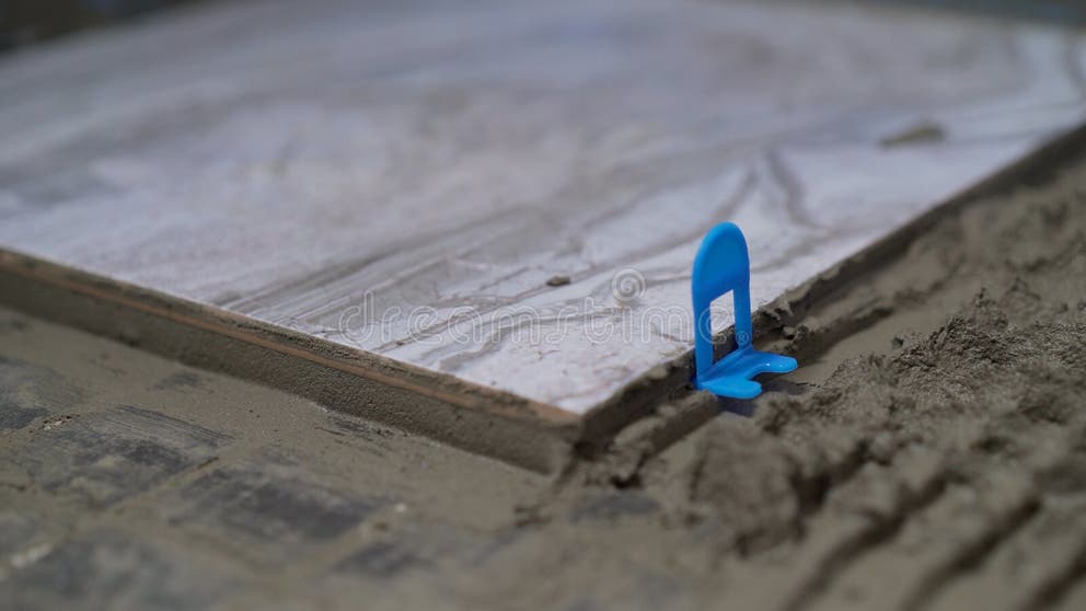 Construction Worker Laying Ceramic Tile Using Tile Leveling System ...