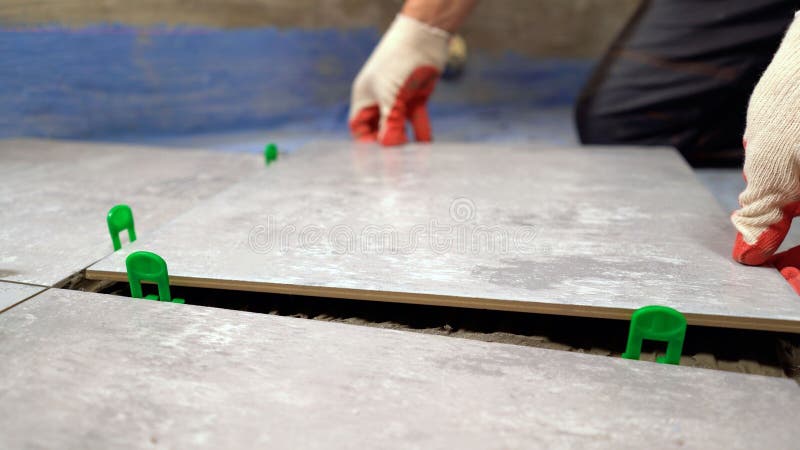 Construction Worker Laying Ceramic Tile on Floor Using Tile Leveling ...