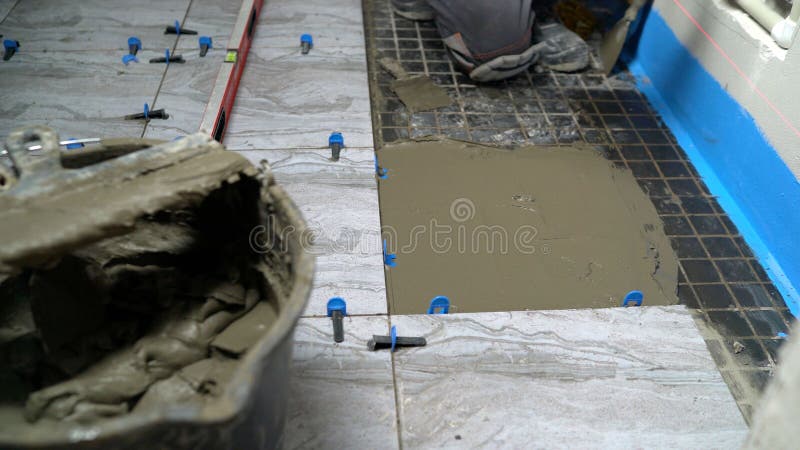 Construction Worker Laying Floor Tiles Using Tile Leveling System and ...
