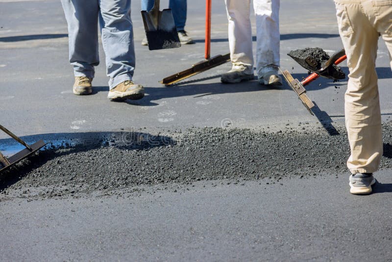 Construction Worker Laying New Asphalt Roads As Part of a Process of ...