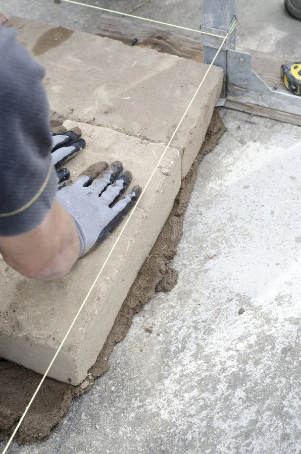 Construction Worker Lays the First Brick of the Wall. Stock Photo ...