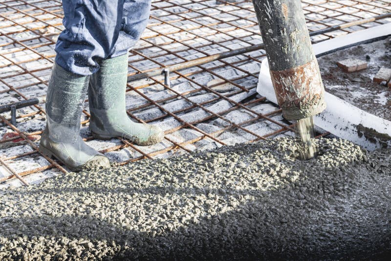 Construction Worker Leveling a Poured Concrete Floor in an Industrial ...