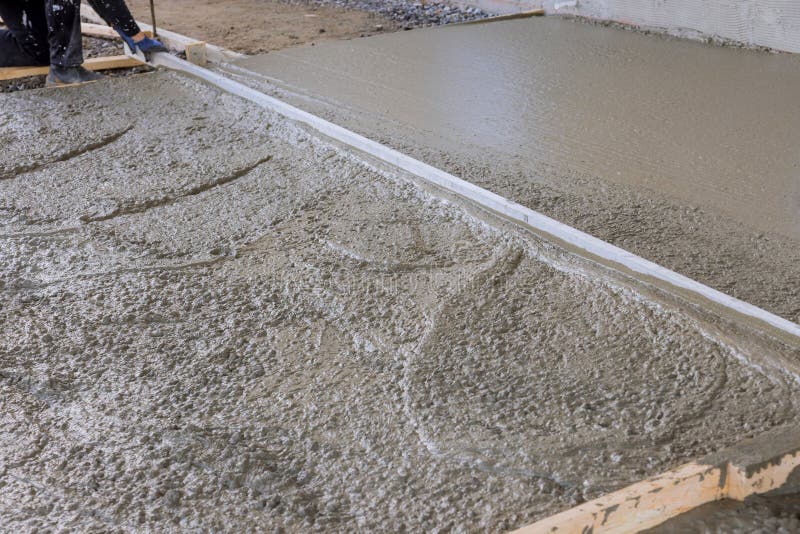 A Construction Worker in Leveling an Poured Concrete with Using Long ...