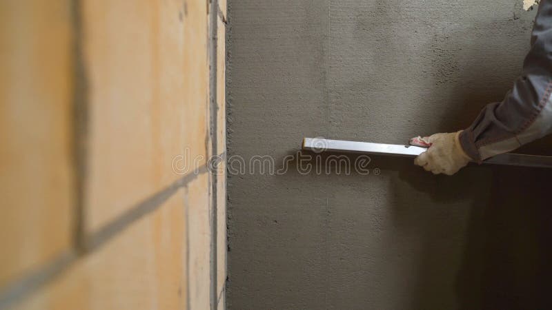 Construction Worker Leveling Wet Cement Plaster on Wall with Aluminum ...