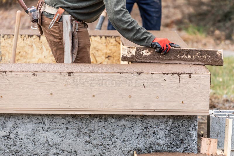 Construction Worker Leveling Wet Cement into Wood Framing Stock Photo ...