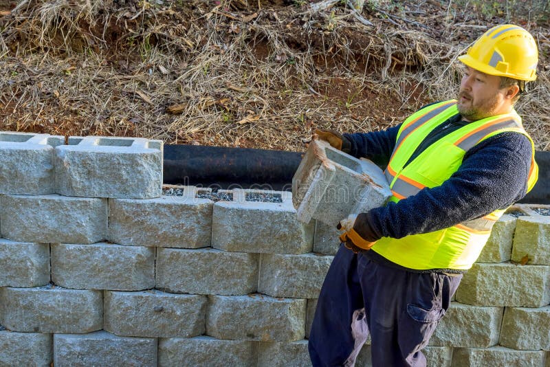 Construction Worker Lifted Concrete Block before Mounting it on the ...