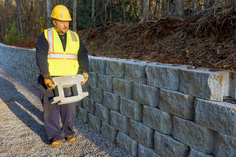 A Construction Worker Mounted Concrete Blocks To Retaining Wall on ...