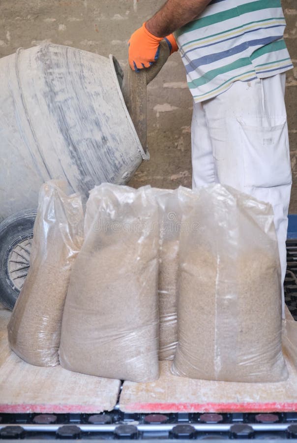 Construction Worker Loading a Sandbag into the Concrete Mixer. Stock ...