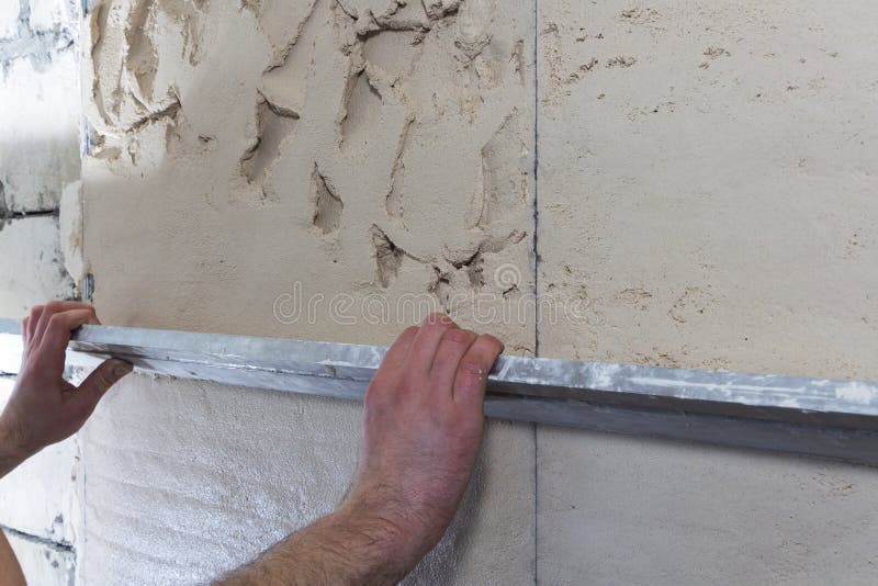 Construction Worker with a Long Spatula To Plaster the Wall by Hand ...