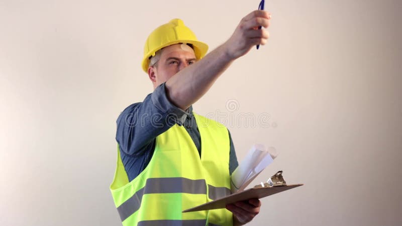 Construction Worker Looking at Papers Then Pointing at Something while ...