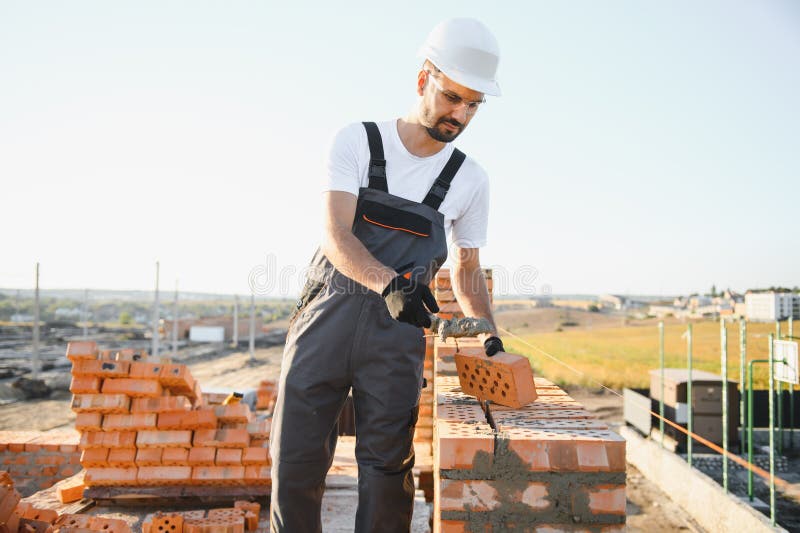 Construction Worker Man in Work Clothes and a Construction Helmet ...