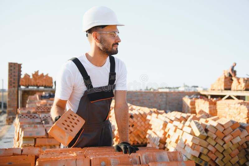 Construction Worker Man in Work Clothes and a Construction Helmet ...