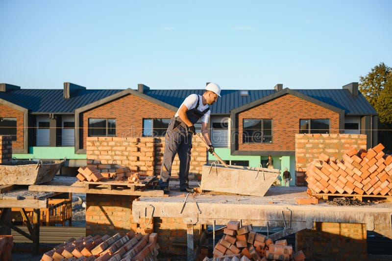 Construction Worker Man in Work Clothes and a Construction Helmet ...