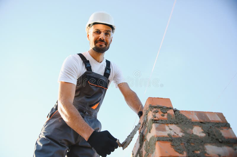 Construction Worker Man in Work Clothes and a Construction Helmet ...