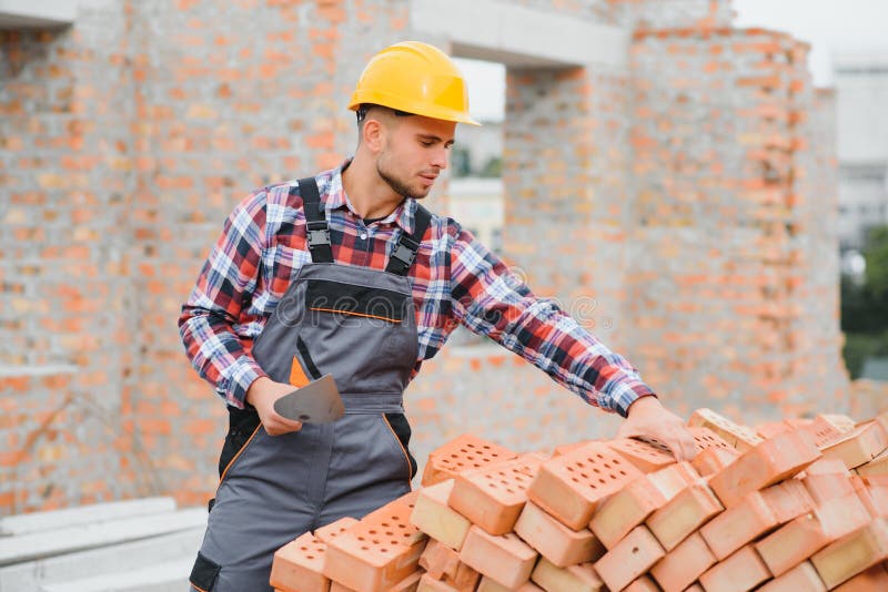 Construction Worker Man in Work Clothes and a Construction Helmet ...