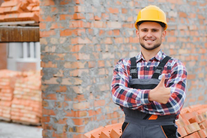 Construction Worker Man in Work Clothes and a Construction Helmet ...