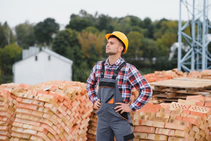 Construction Worker Man in Work Clothes and a Construction Helmet ...