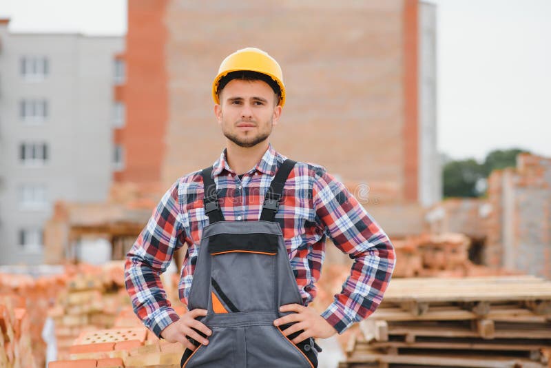 Construction Worker Man in Work Clothes and a Construction Helmet ...
