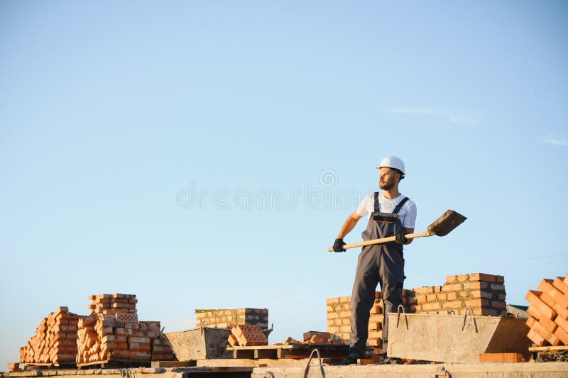 Construction Worker Man in Work Clothes and a Construction Helmet ...