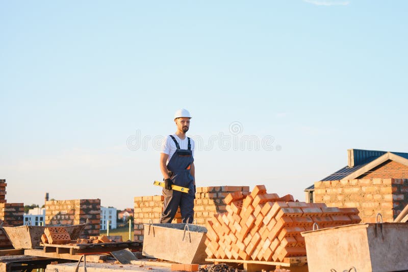 Construction Worker Man in Work Clothes and a Construction Helmet ...