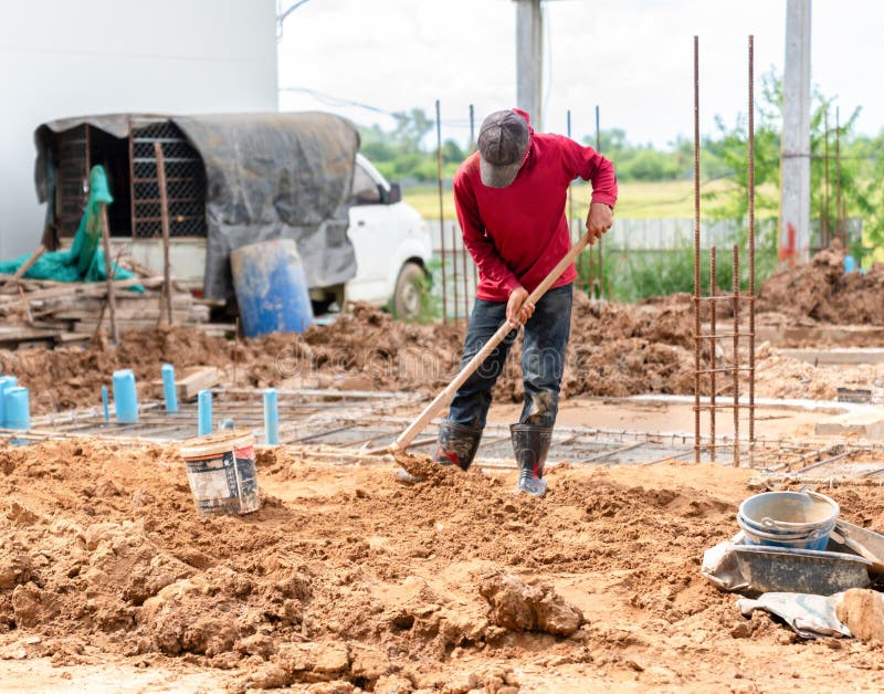 A Construction Worker is Manually Digging and Leveling Sand Using a Hoe ...