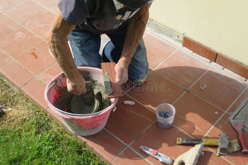 Construction Worker with a Mask Installing Tiles on the Wall Stock ...