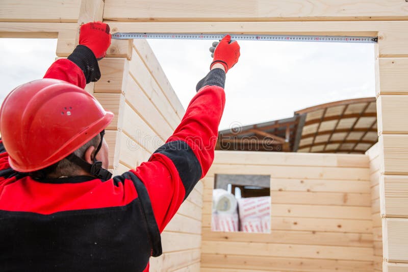 Construction Worker Measures the Timber of a New Wooden Building. Stock ...