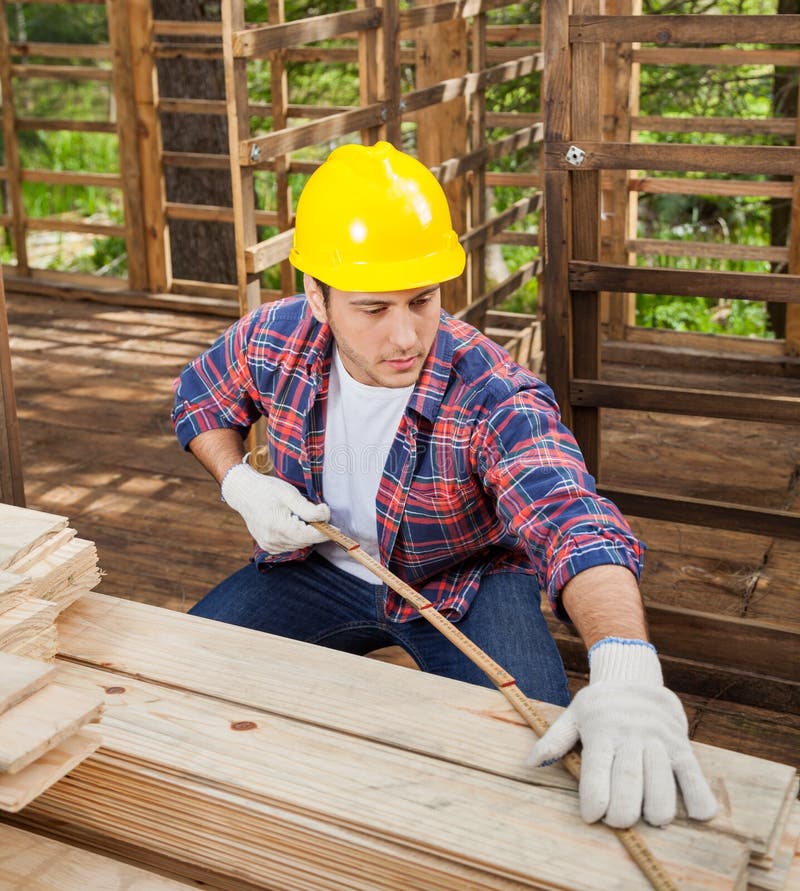 Construction Worker Measuring Wooden Plank at Site Stock Image - Image ...