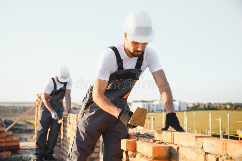 Construction Worker Man in Work Clothes and a Construction Helmet ...