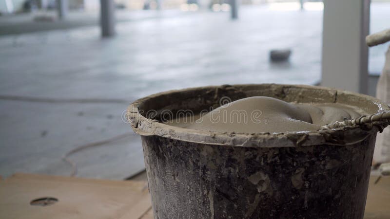 Construction Worker Mixing Cement in a Bucket on a Construction Site ...
